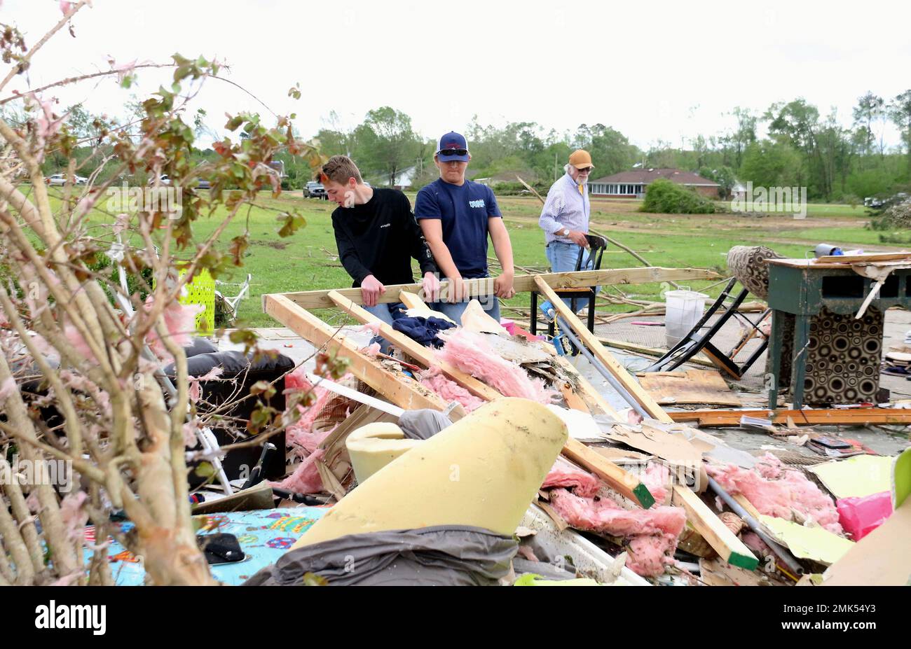 Riley Carter, left and Thomas Boles, center help Jerry Whitaker, right ...