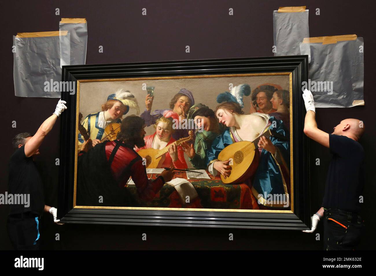 Employees prepare a painting 'The concert' (1623) by Gerard van ...