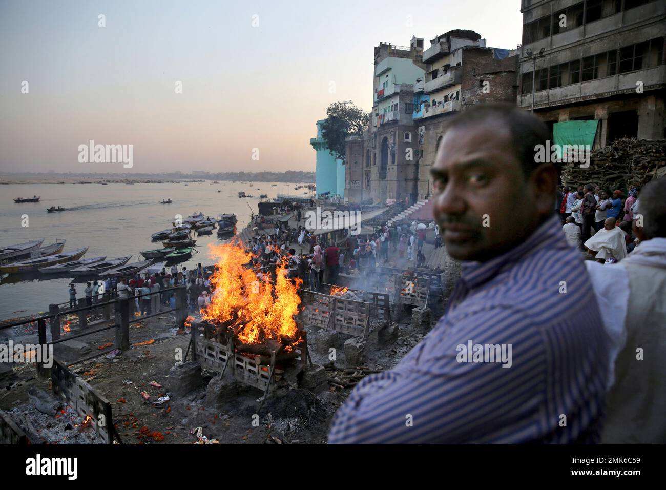 In this March 19, 2019, photo, funeral pyres burn on the banks of river ...