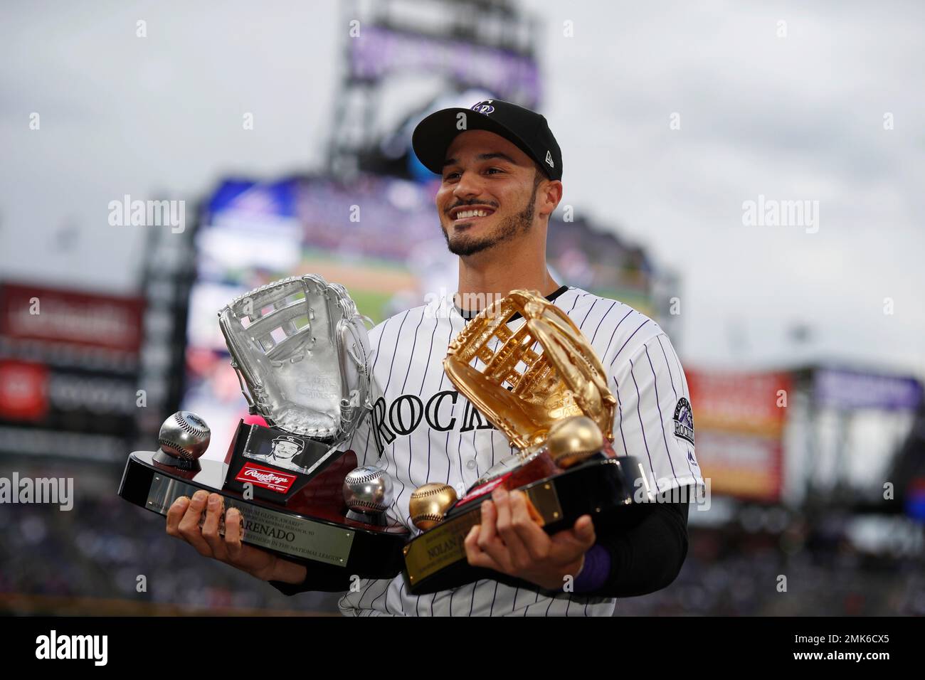 Colorado Rockies third baseman Nolan Arenado smiles as he holds up the ...