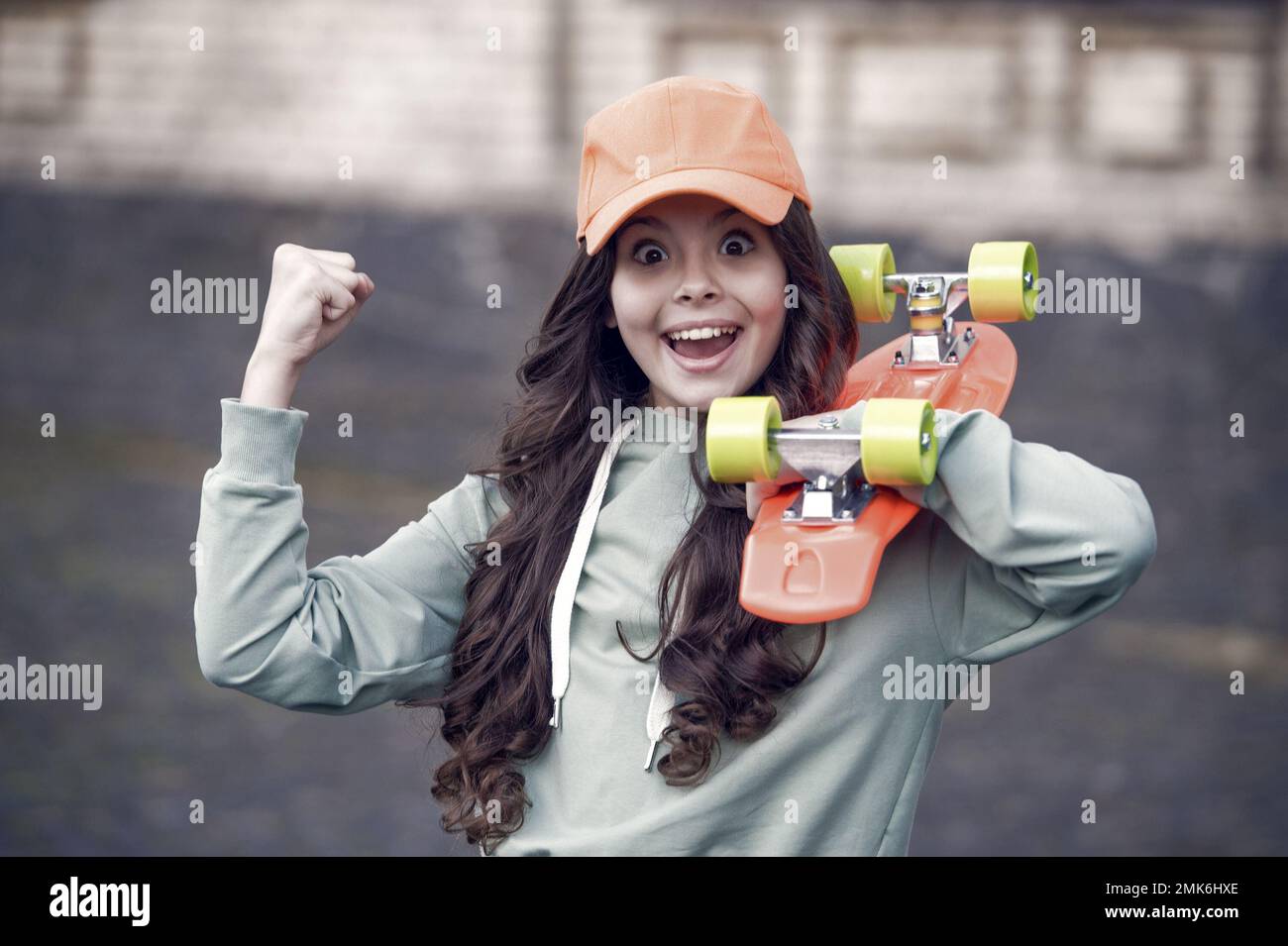Powerslide done. Happy kid hold penny board outdoors. Penny board rider ...