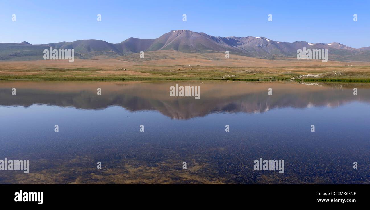 Mountains reflecting in a lake along the At-Bashy Range, Naryn Region ...