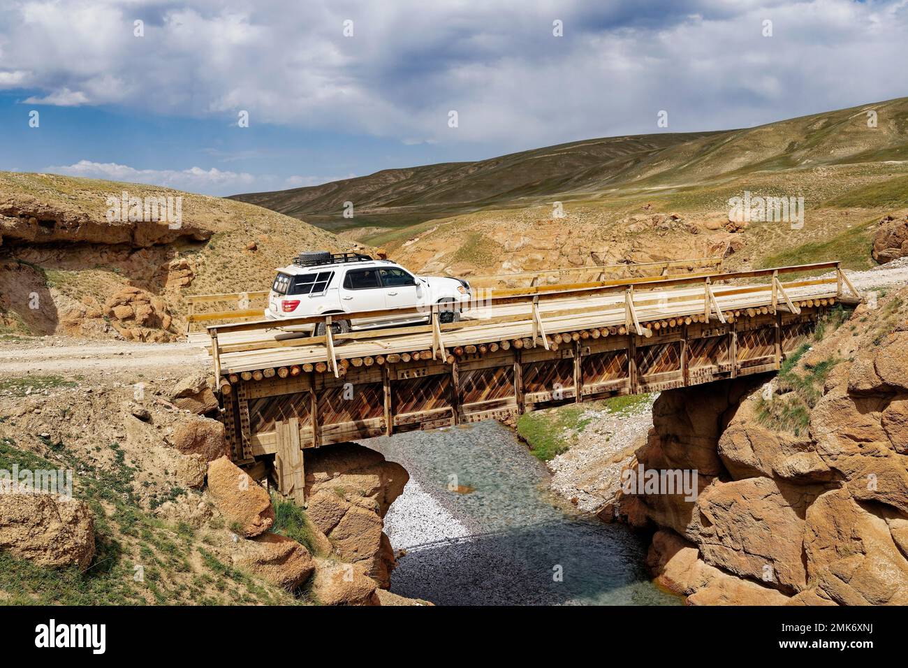 Four-wheel drive car crossing a wooden bridge over a wild gorge, Naryn ...