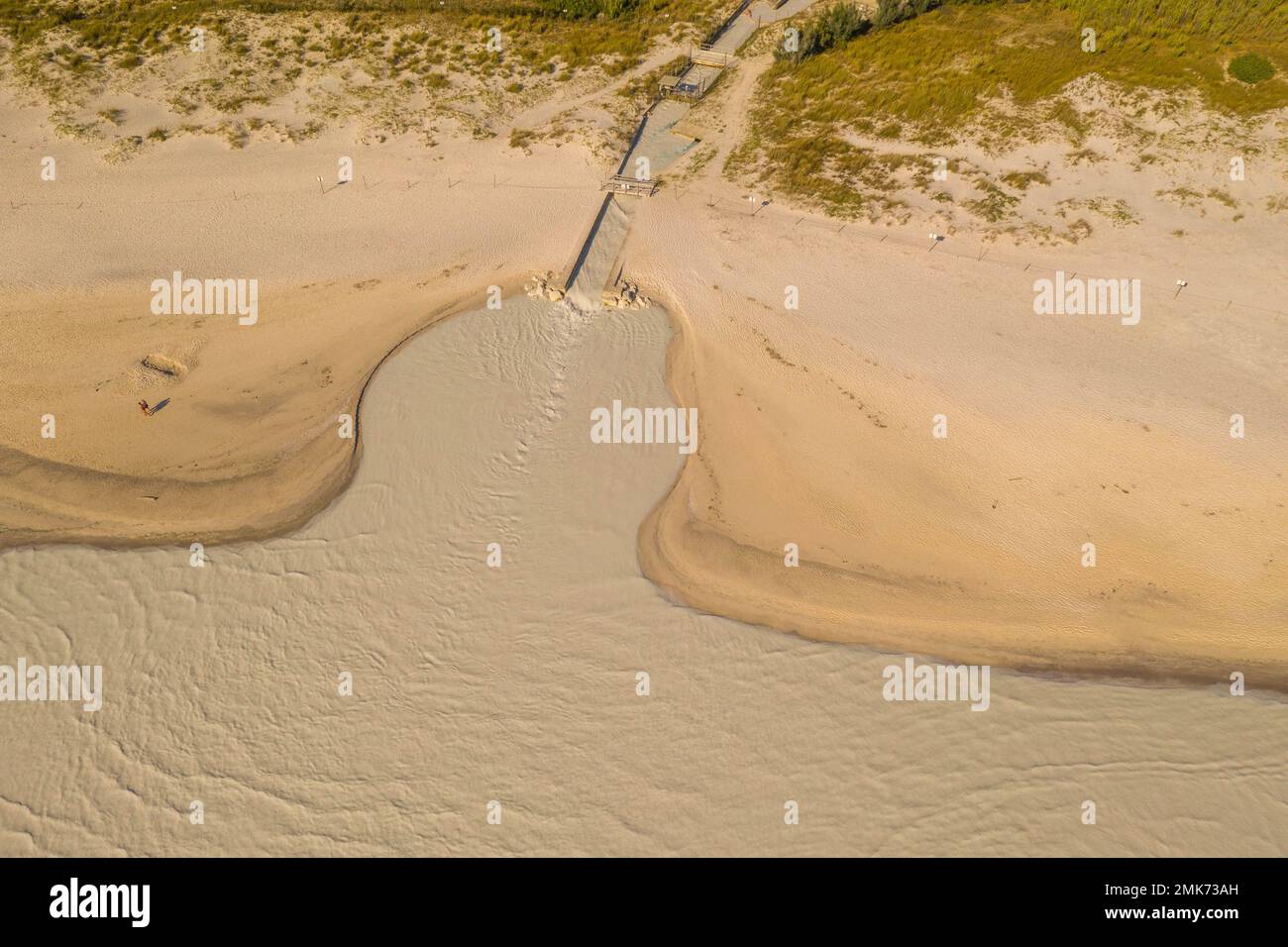 Drone photography of river ending in ocean dumping factory water during ...