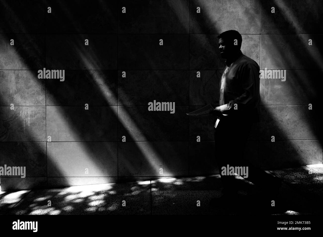 Seattle, USA. 27 May, 2022. A person passing through harsh shadows and ...