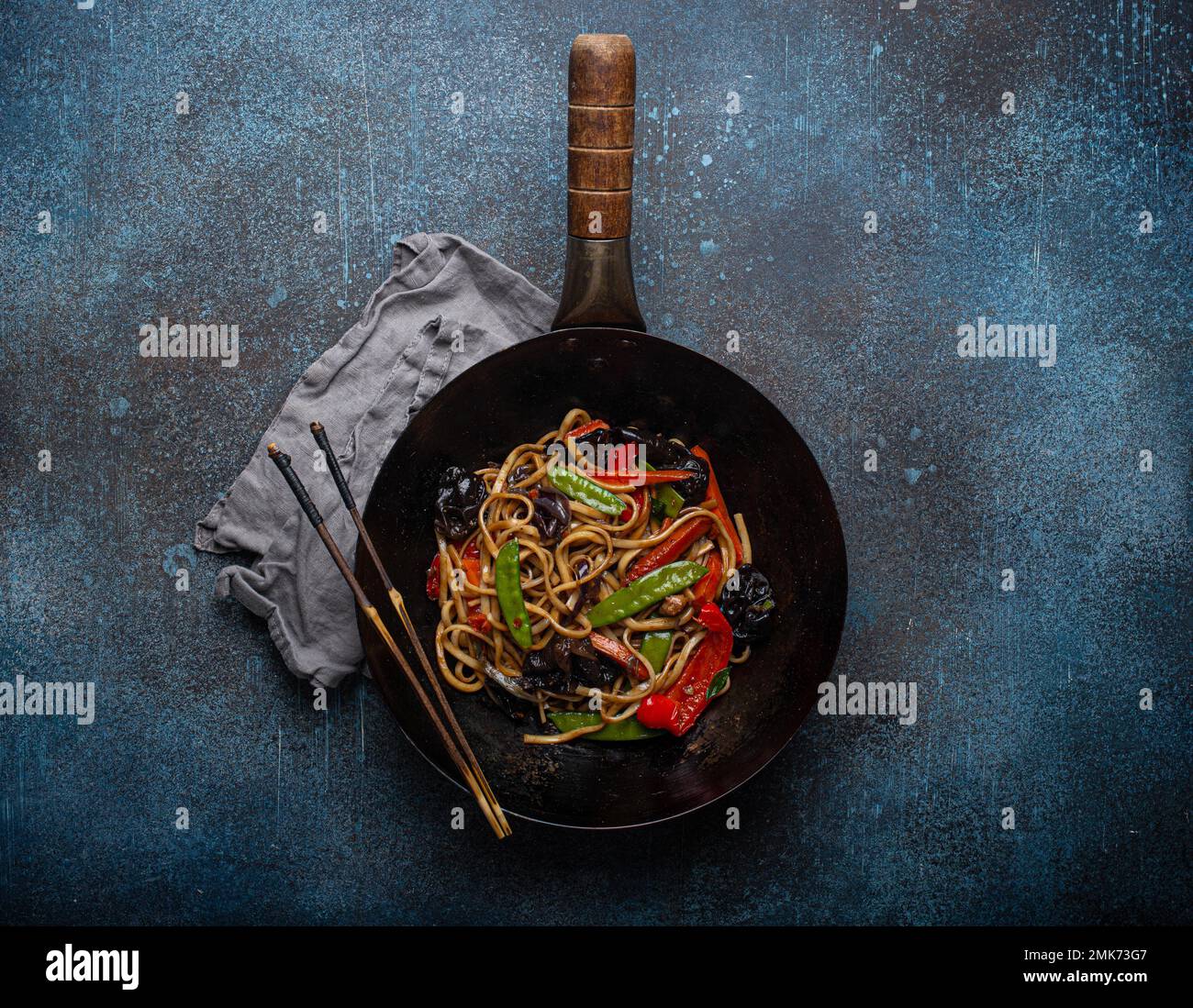 Asian dish stir fry udon noodles with vegetables and mushrooms in black ...