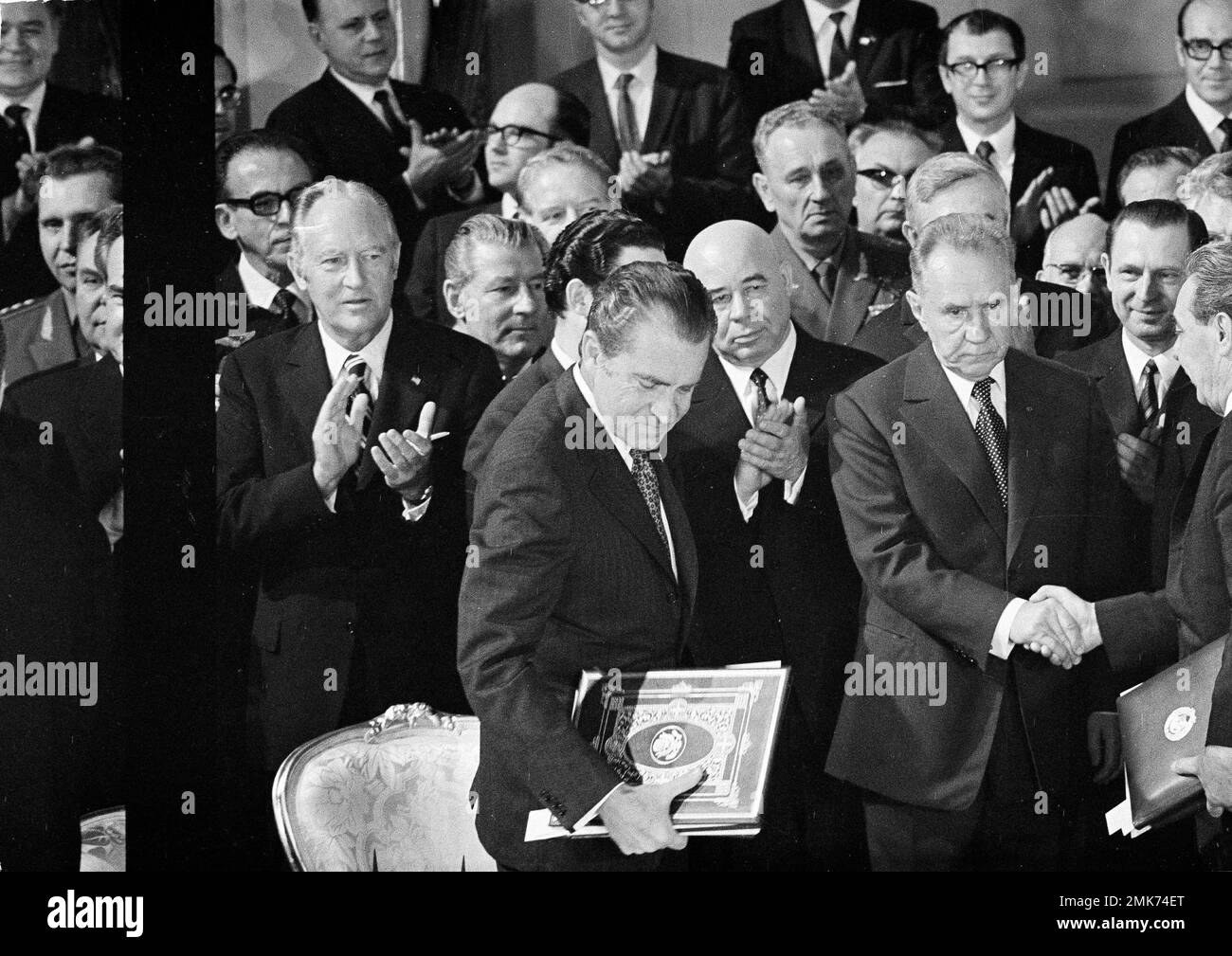 President Richard Nixon, left, smiles as he glances at a copy of ...