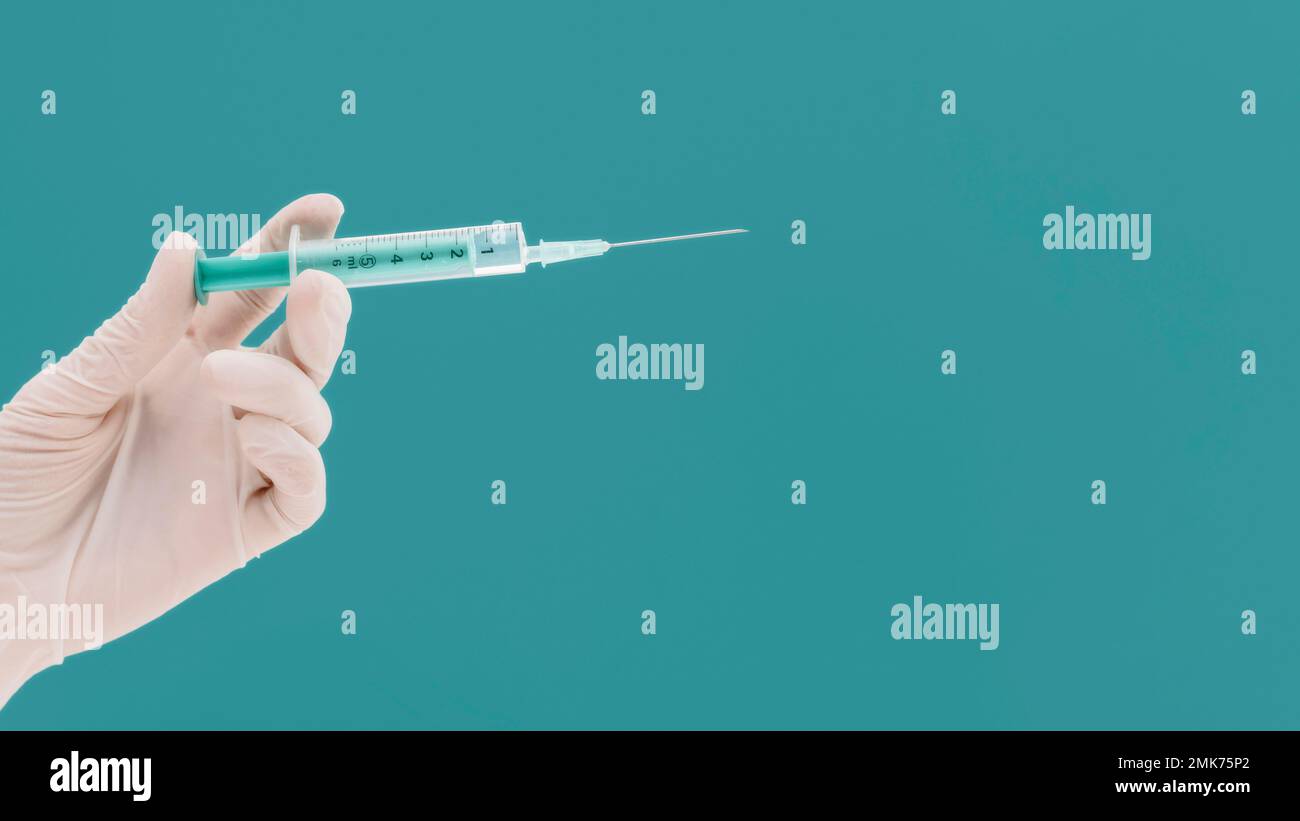 syringe held by hand glove. High resolution photo Stock Photo - Alamy