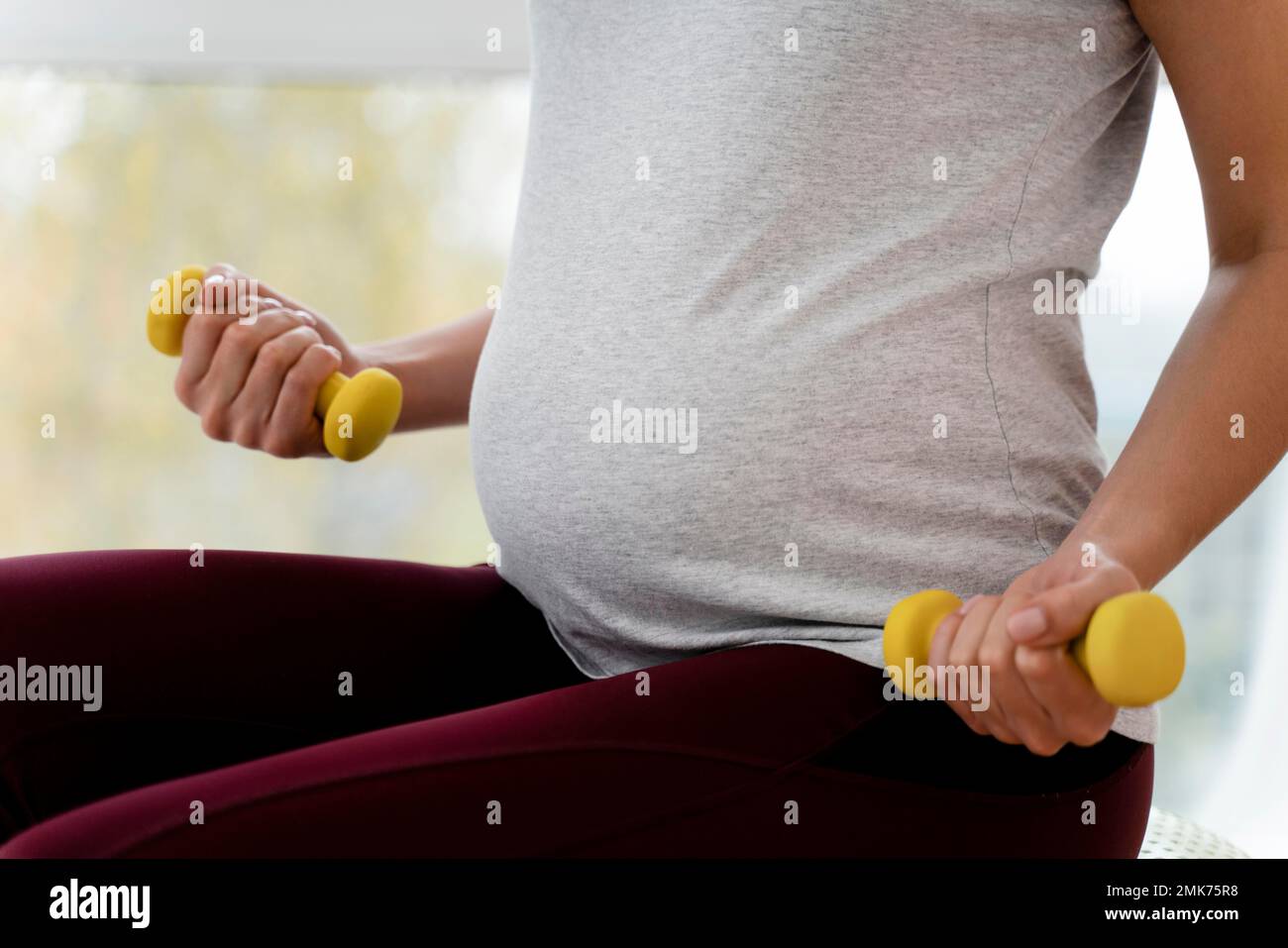 pregnant woman using yellow weights. High resolution photo Stock Photo ...