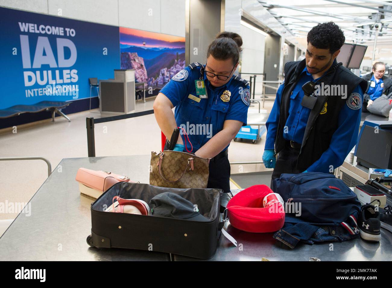Transportation Security Administration (TSA) Officers search handbags ...