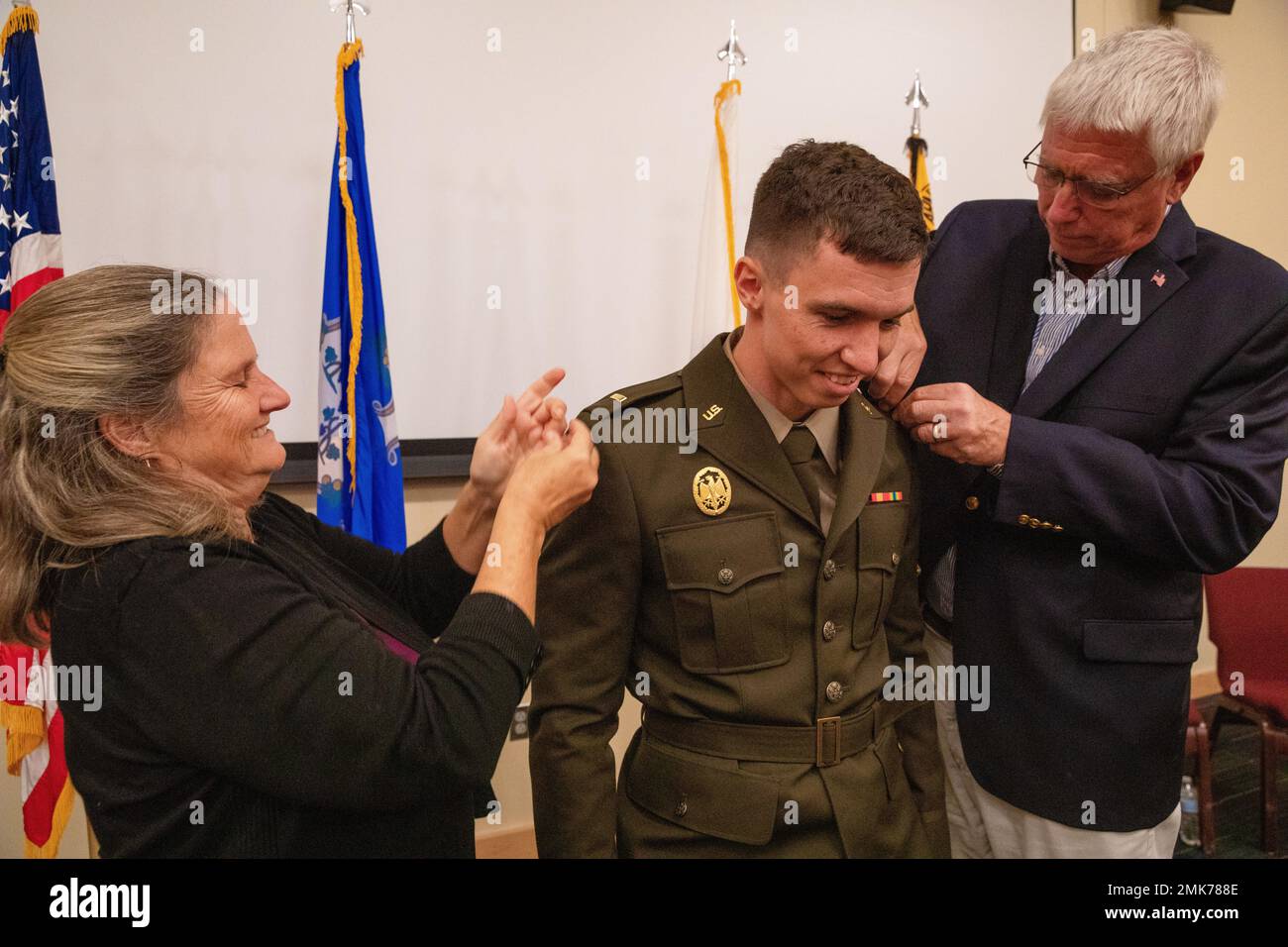 U.S. Army 2nd Lt. Brian Goggin leans down so his family, Susan Goggin ...