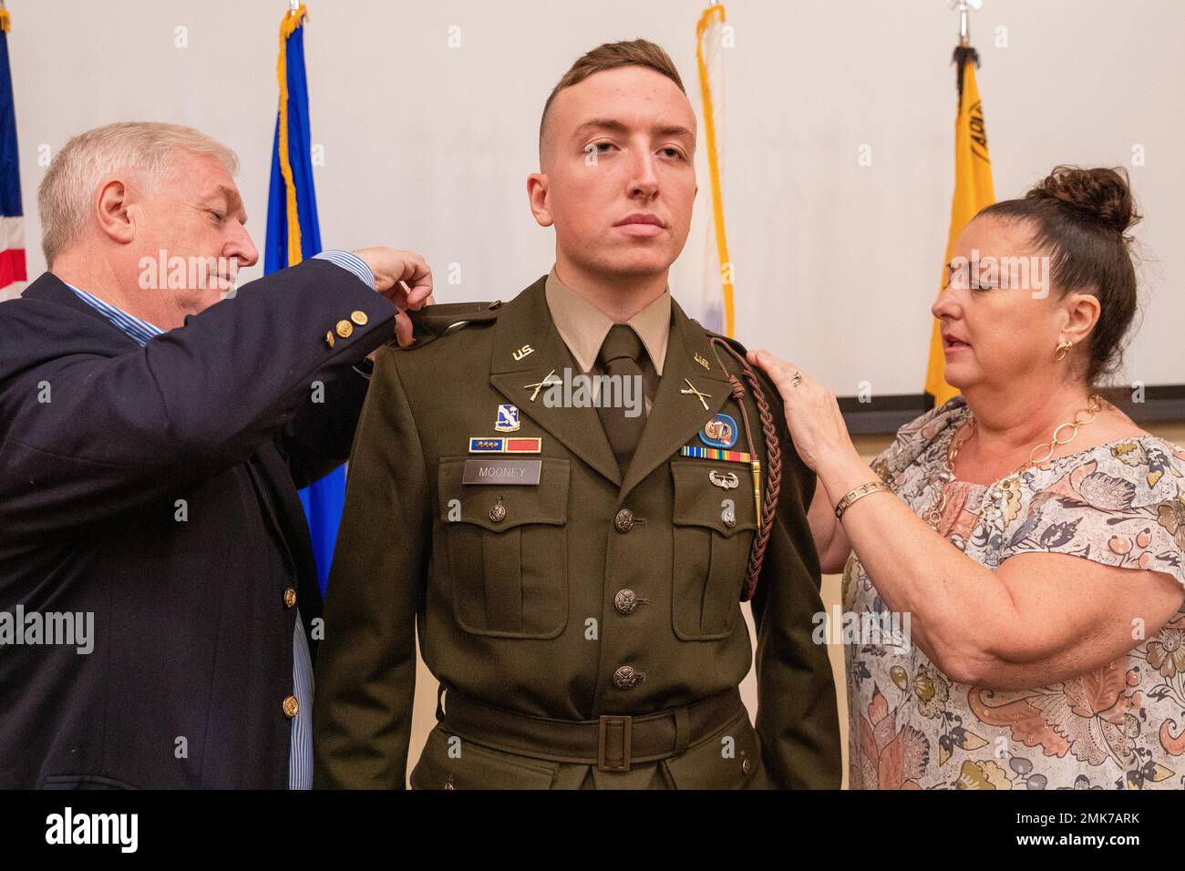 U.S. Army 2nd Lt. Luke Mooney stands at attention while his family ...