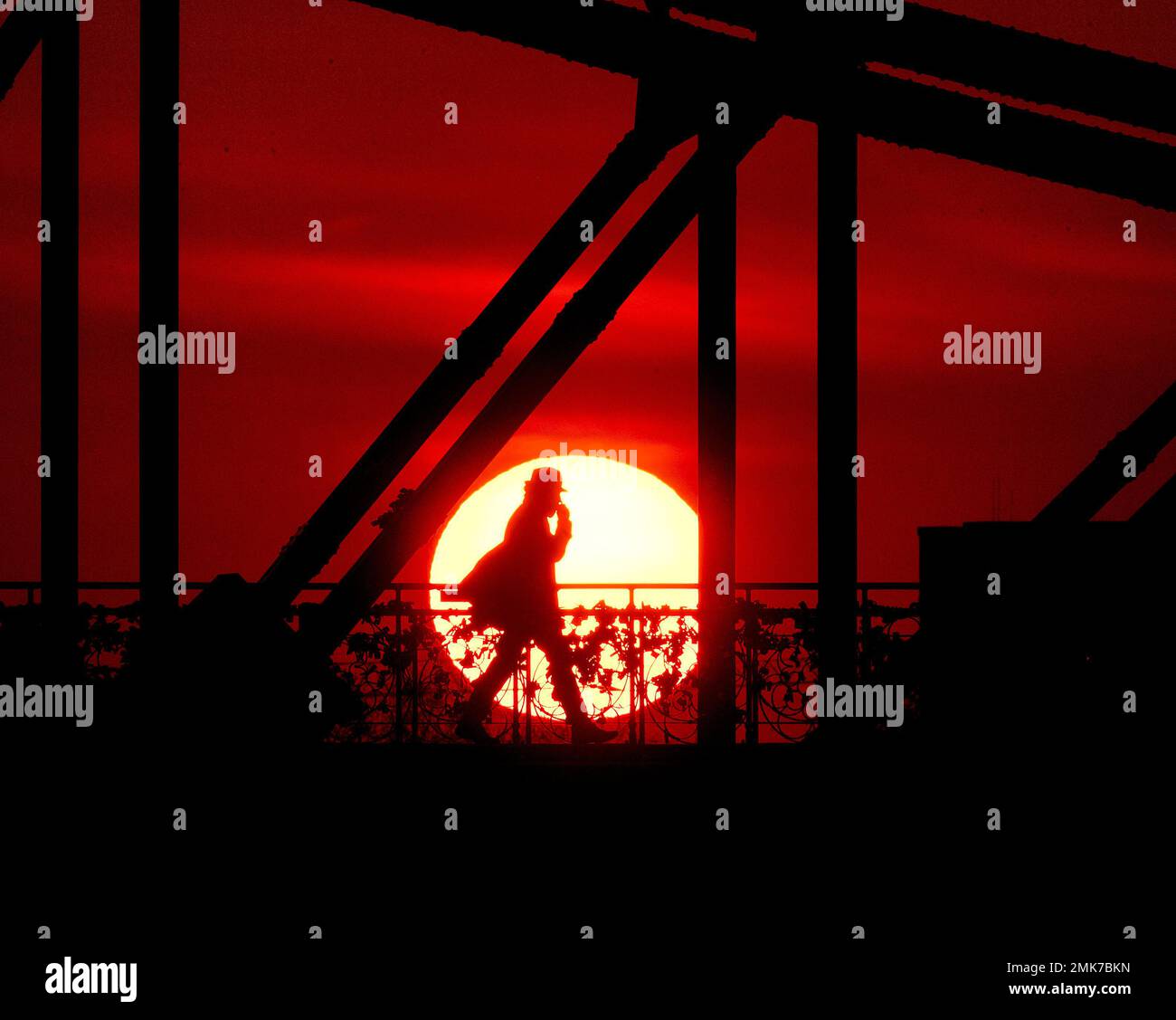 The sun rises behind the 'Eiserne Steg' (Iron Footbridge) pedestrian ...