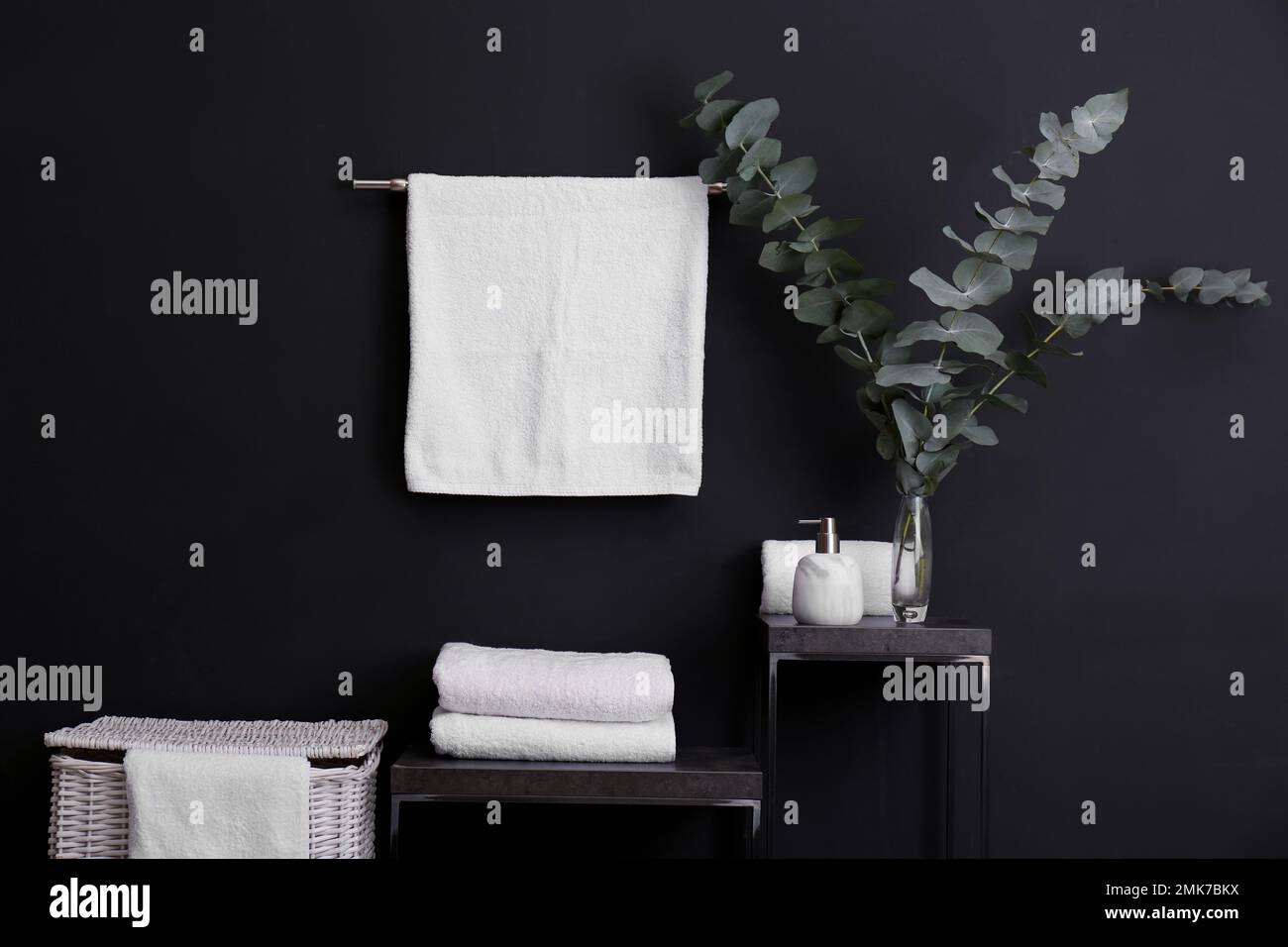 Clean soft towels on stand near black wall Stock Photo - Alamy