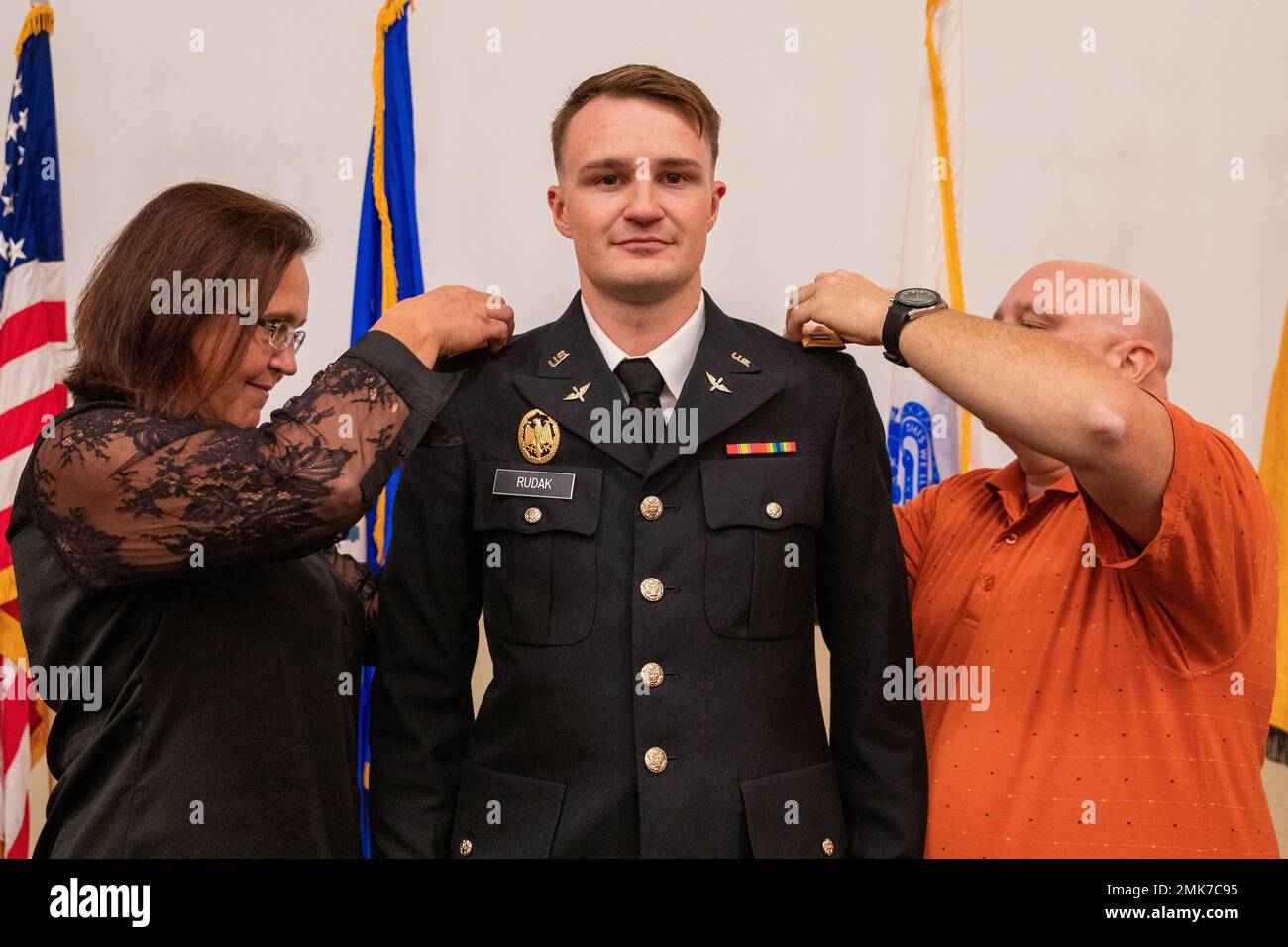 U.S. Army 2nd Lt. Phil Rudak stands at attention while his family ...