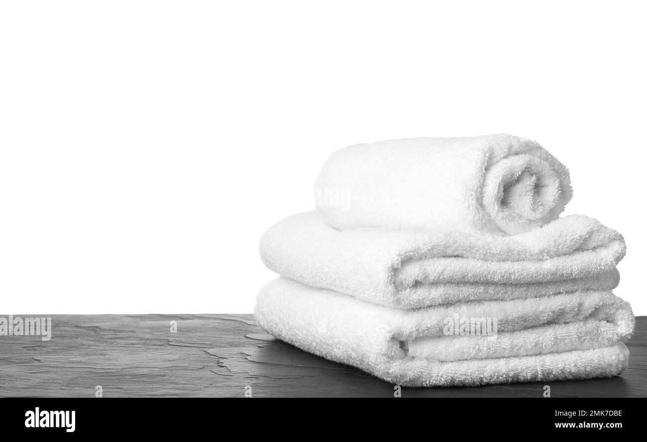 Folded fresh clean towels for bathroom on table against white ...