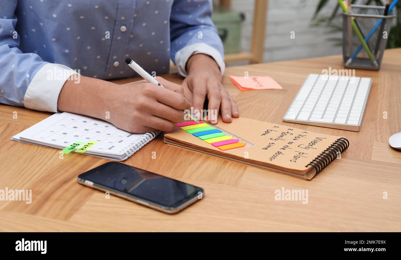 Woman making schedule using calendar at table in office, closeup Stock ...
