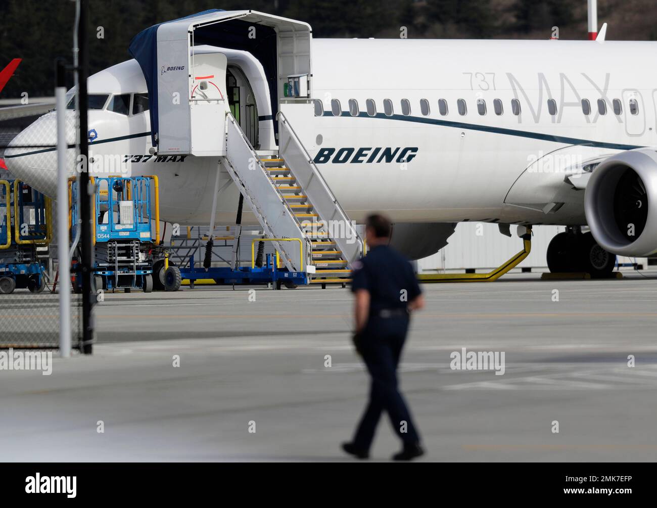 FILE - In this March 14, 2019, file photo, a worker walks next to a ...