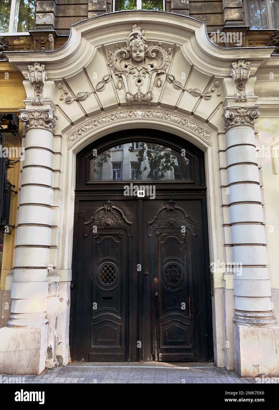 Large carved double doors are surrounded with columns and cherub head ...