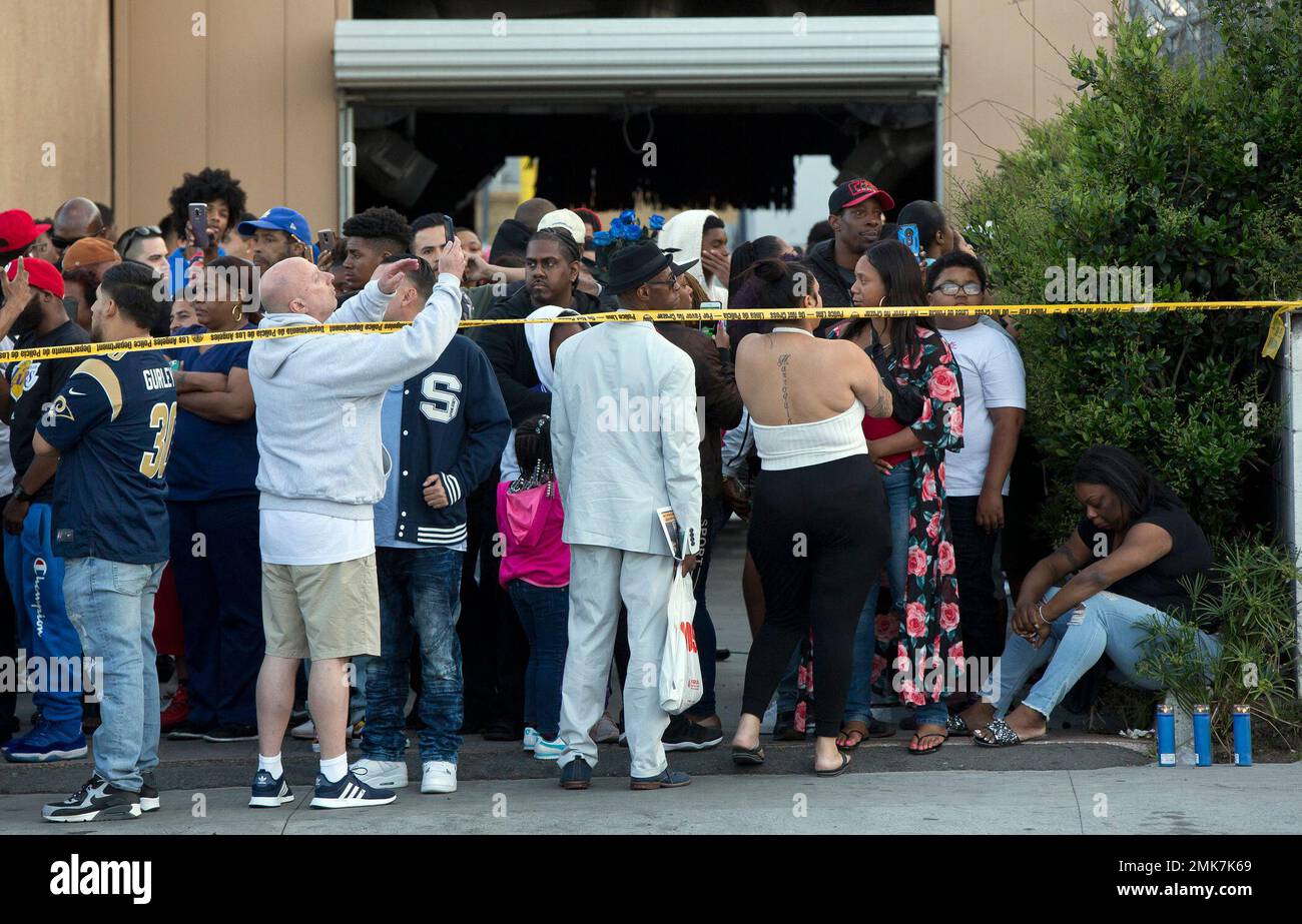 People gather near the Marathon Clothing store of rapper Nipsey Hussle ...