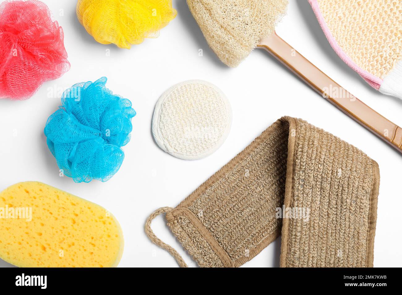 Plastic and natural shower sponges on white background, top view ...