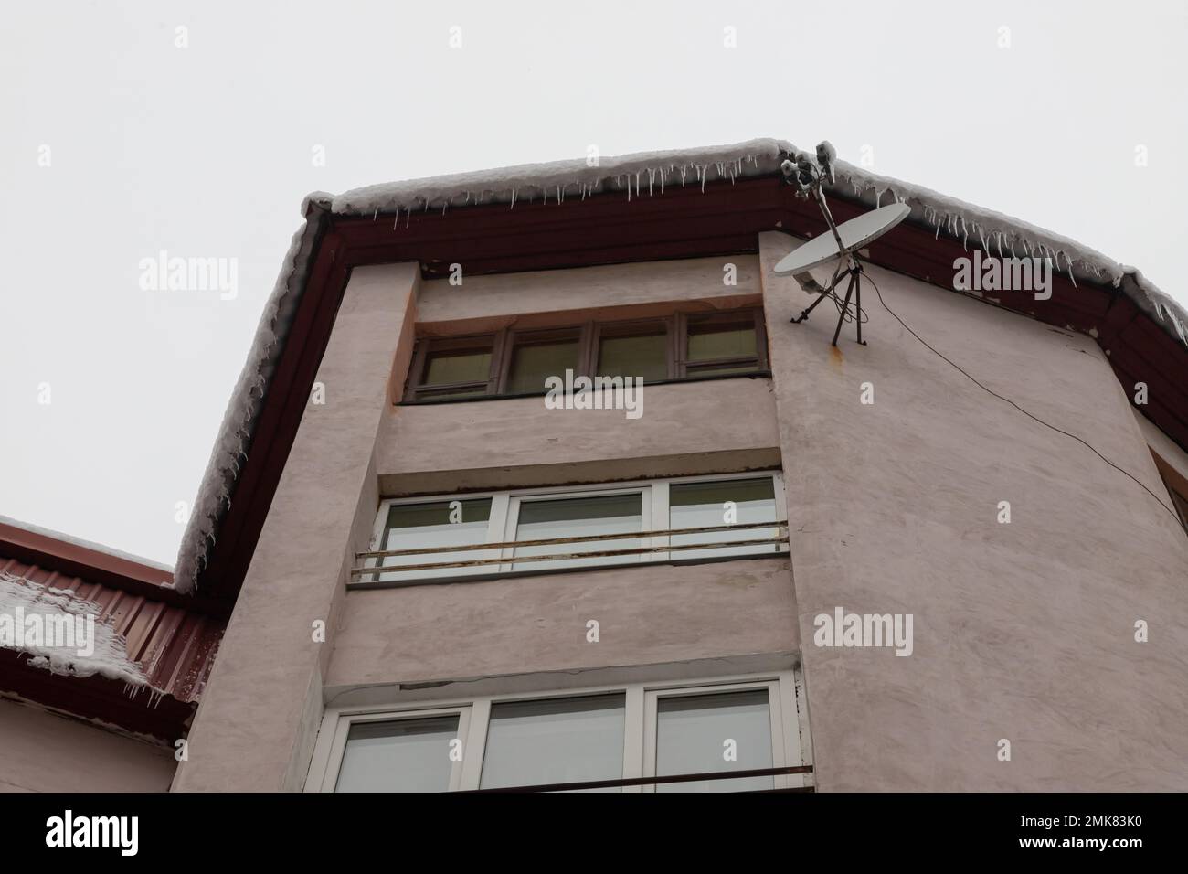 Facade of a residential building in the suburbs during a snowfall. The ...
