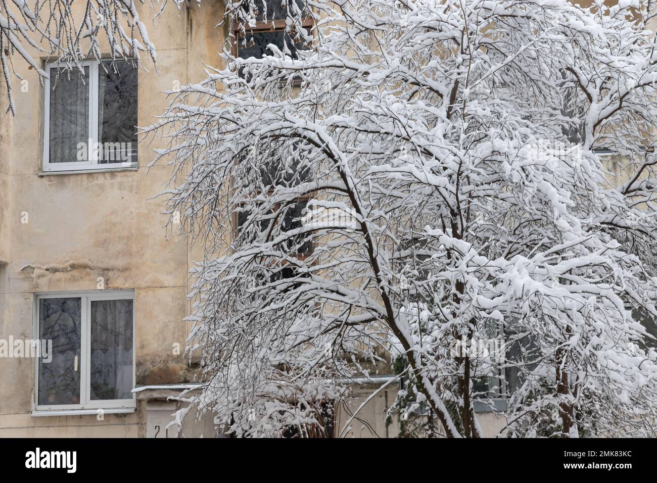 Facade of a residential building in the suburbs during a snowfall. The ...