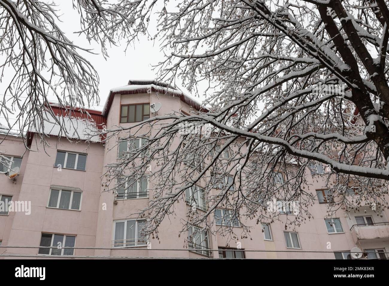 Facade of a residential building in the suburbs during a snowfall. The ...