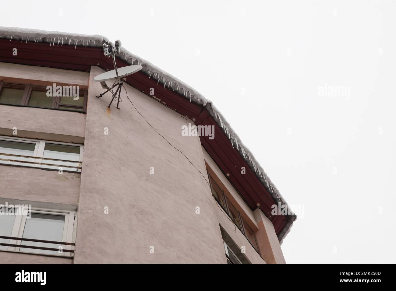 Facade of a residential building in the suburbs during a snowfall. The ...