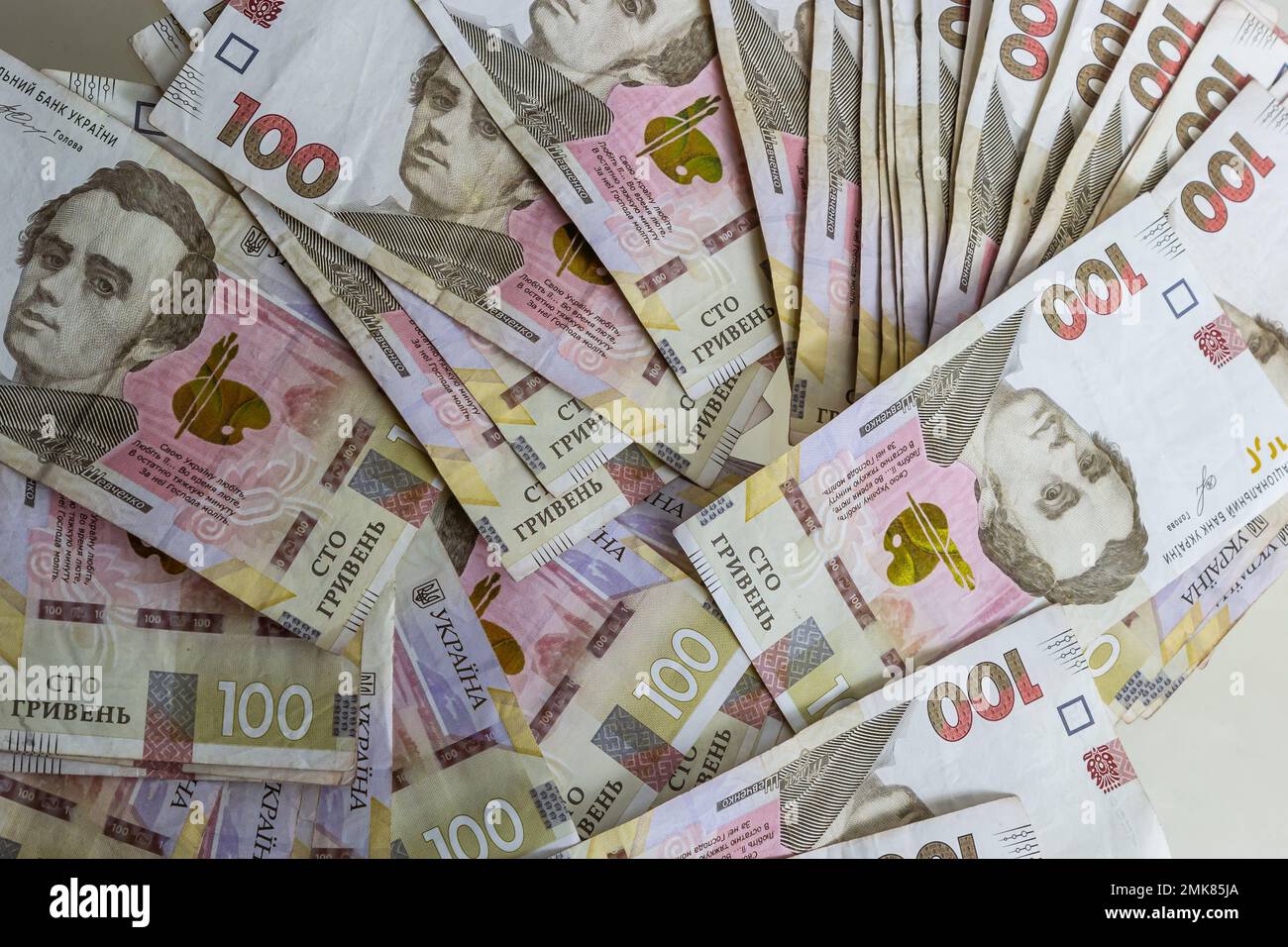 Ukrainian paper money is laid out on a blue background. 100 hryvnia ...