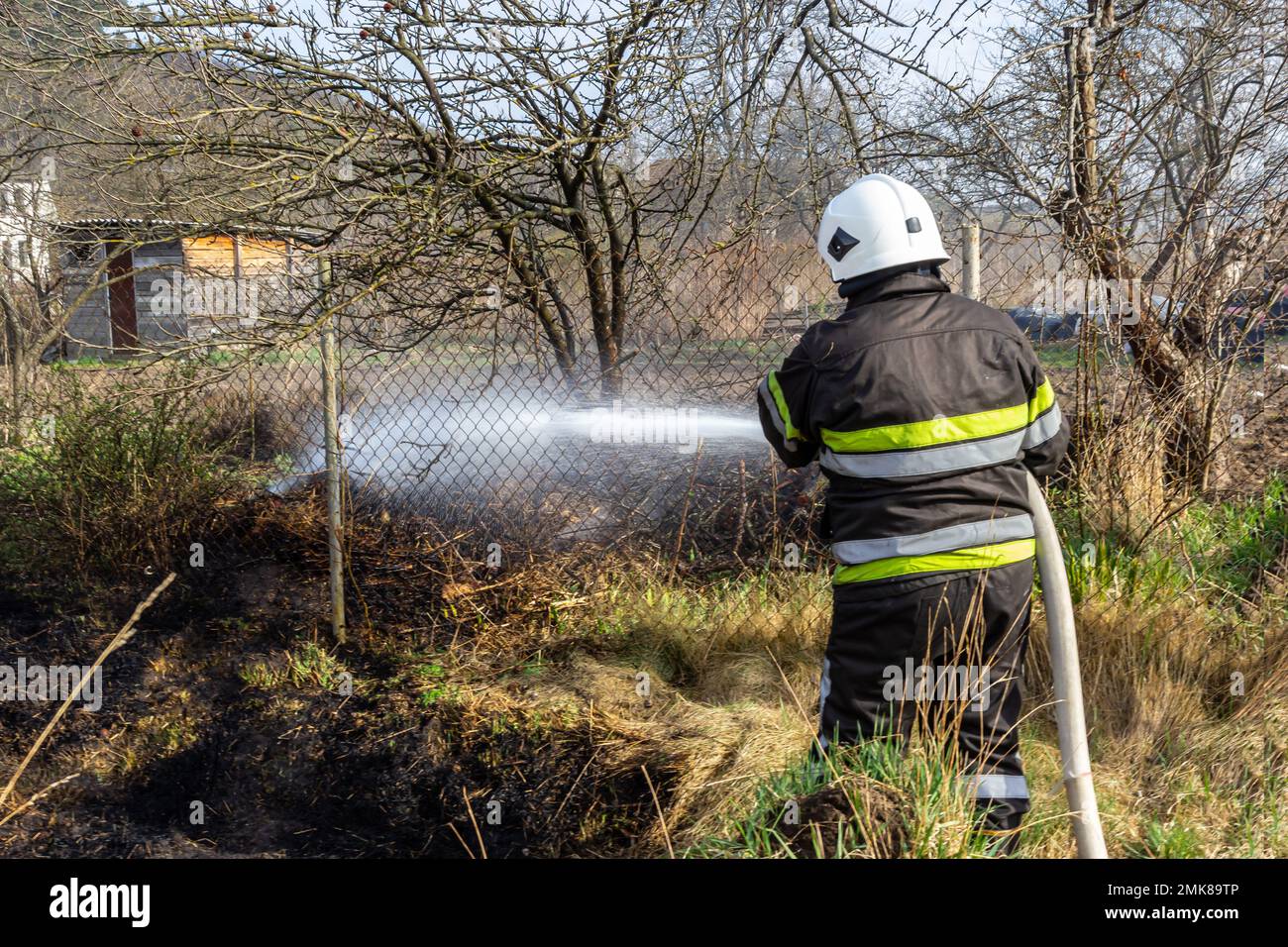 spring fire, burning dry grass near buildings in the countryside ...