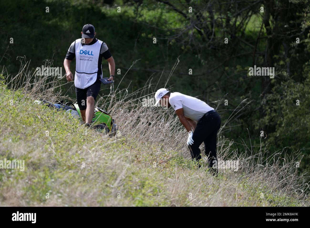 Xander Schauffele, right, examines his ball in the rough during round ...