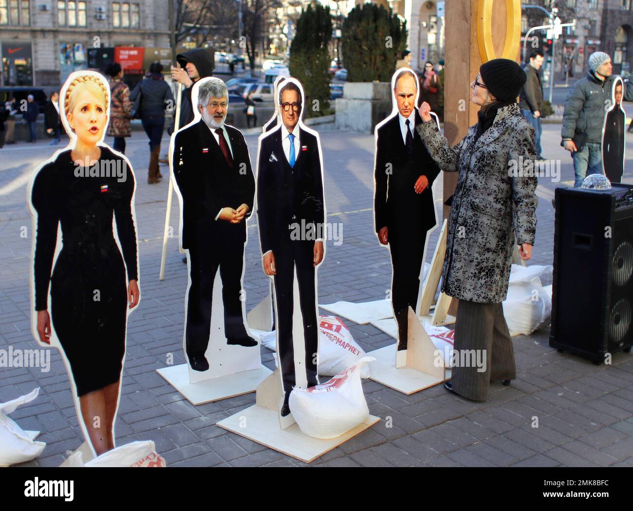 A woman gestures to cardboard image of Russian President Vladimir Putin ...