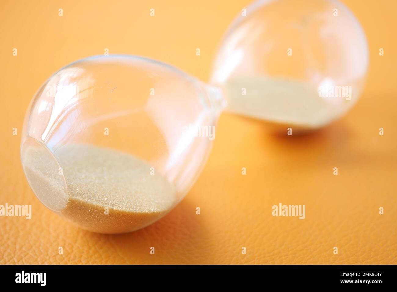 hourglass on table, sand flowing through the bulb of sandglass Stock ...