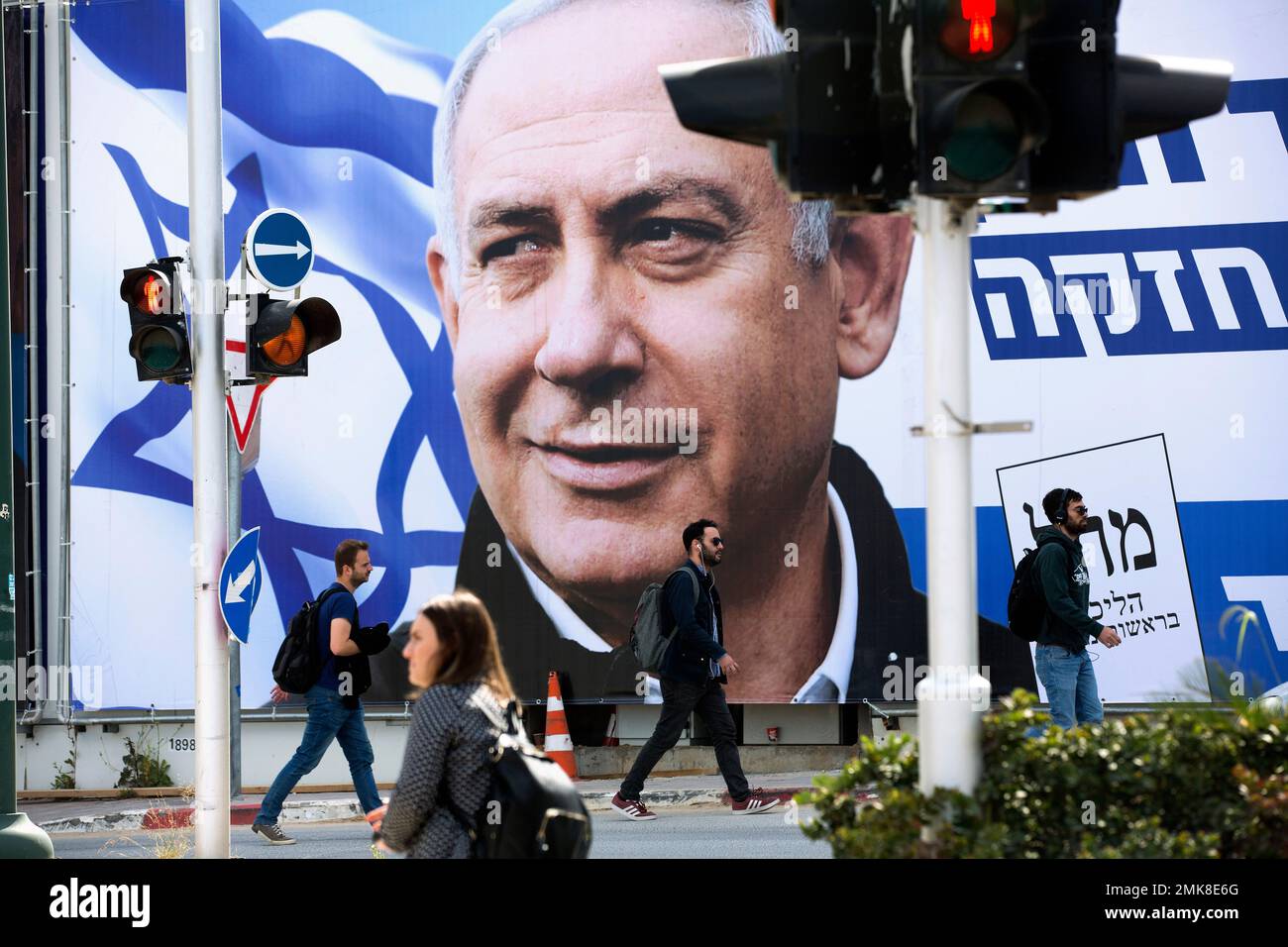 People walk by an election campaign billboard showing Israel's Prime ...