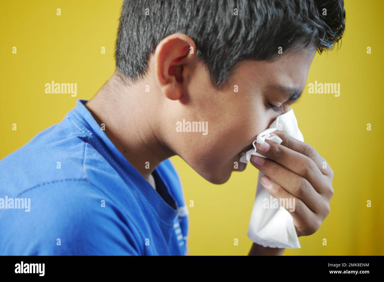 Sick boy with flu blow nose with napkin Stock Photo - Alamy