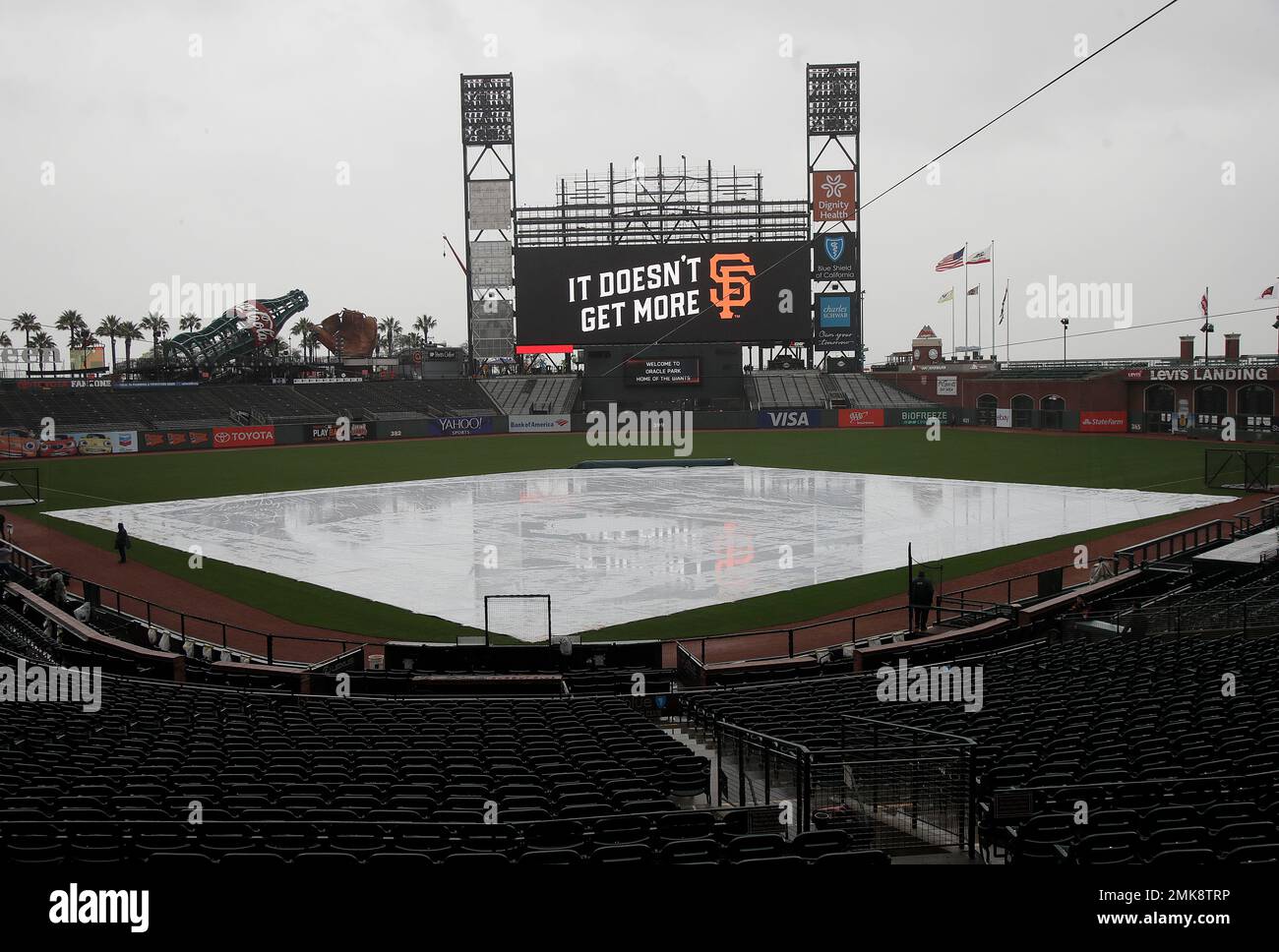 A tarp covers the field beneath a scoreboard under construction at ...