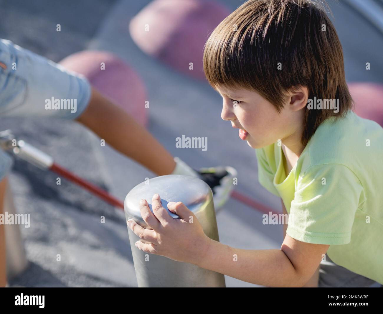Boy climbes up a concrete slope of modern children's sports and ...