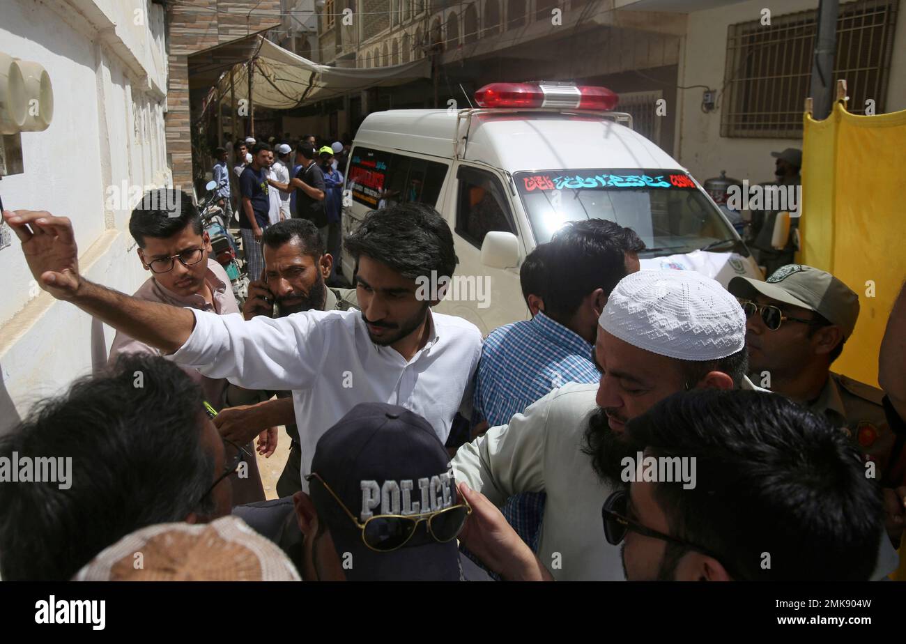 People make way for an ambulance carrying the body of shooting victim ...