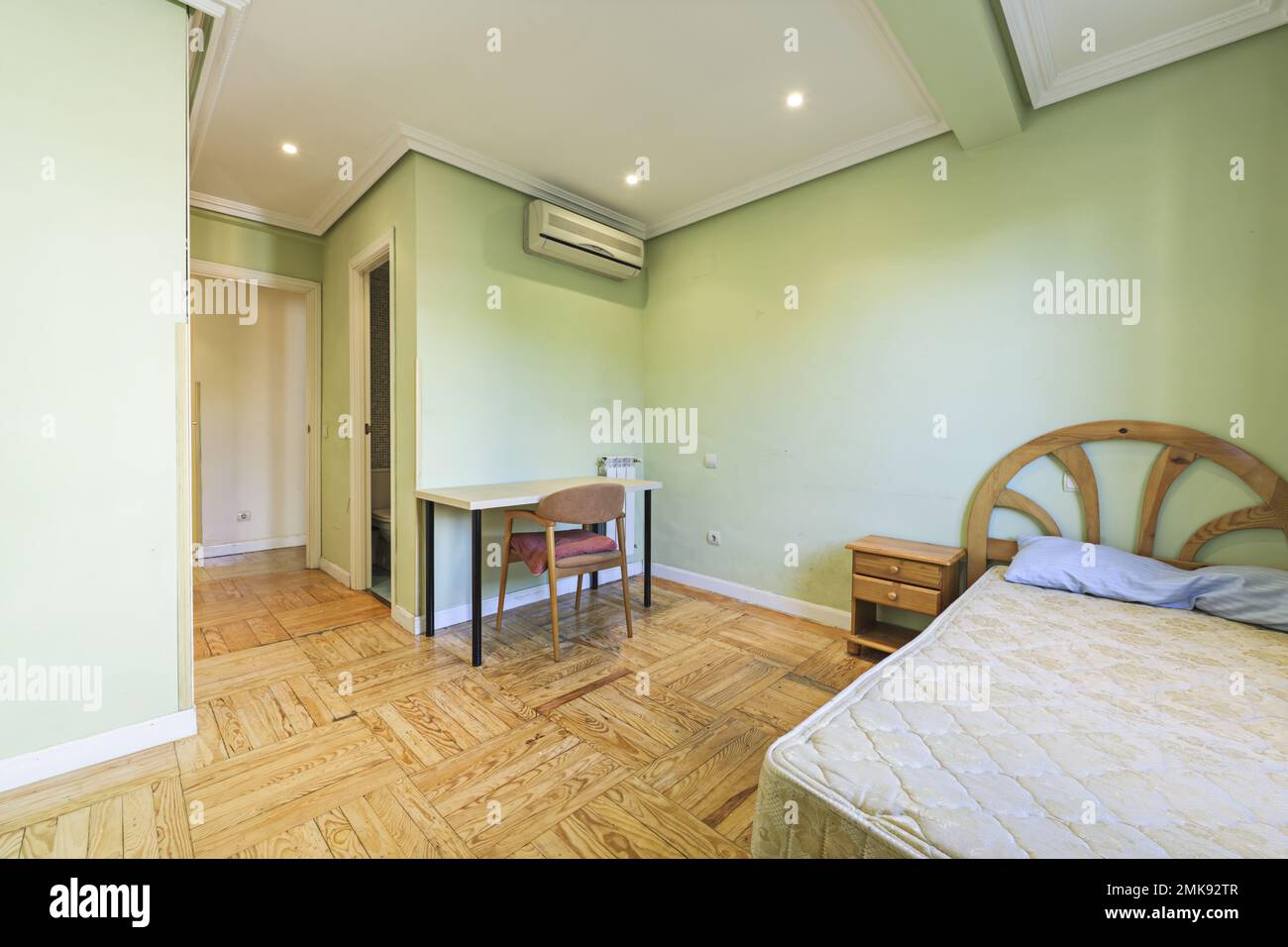 Bedroom with a single bed with a mattress without bedding and a desk ...