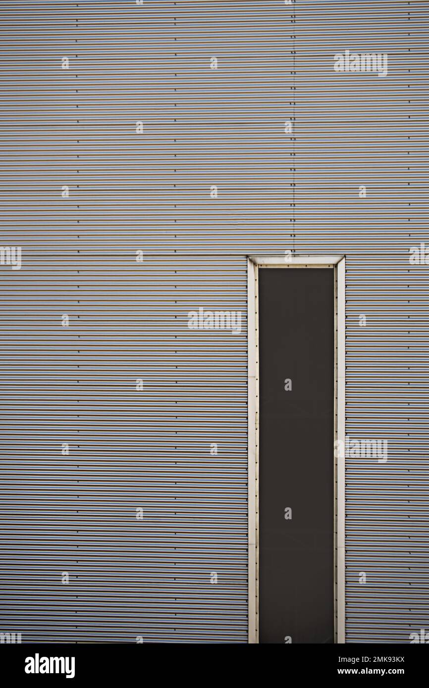 Facade of a building covered with corrugated metal and a vertical ...
