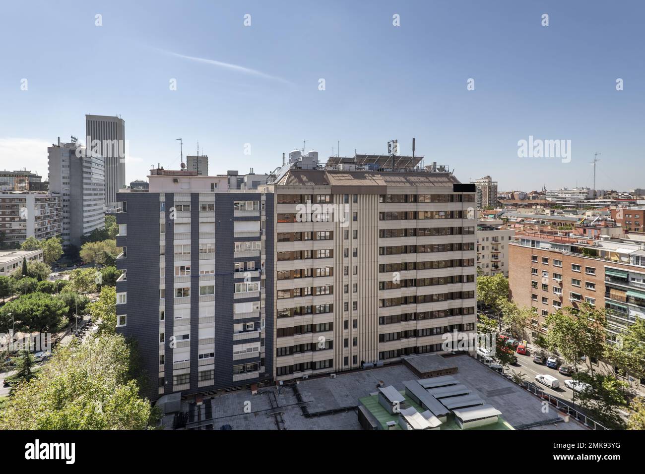 Facade of residential and office buildings in a tree-lined block and ...