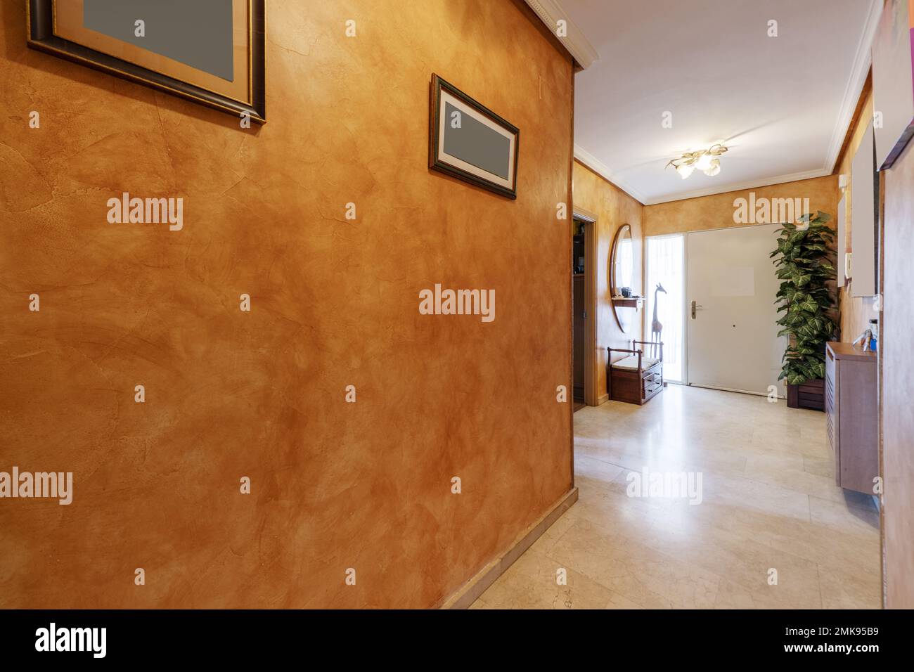 Hallway of a detached house with cream marble floors and a white exit ...