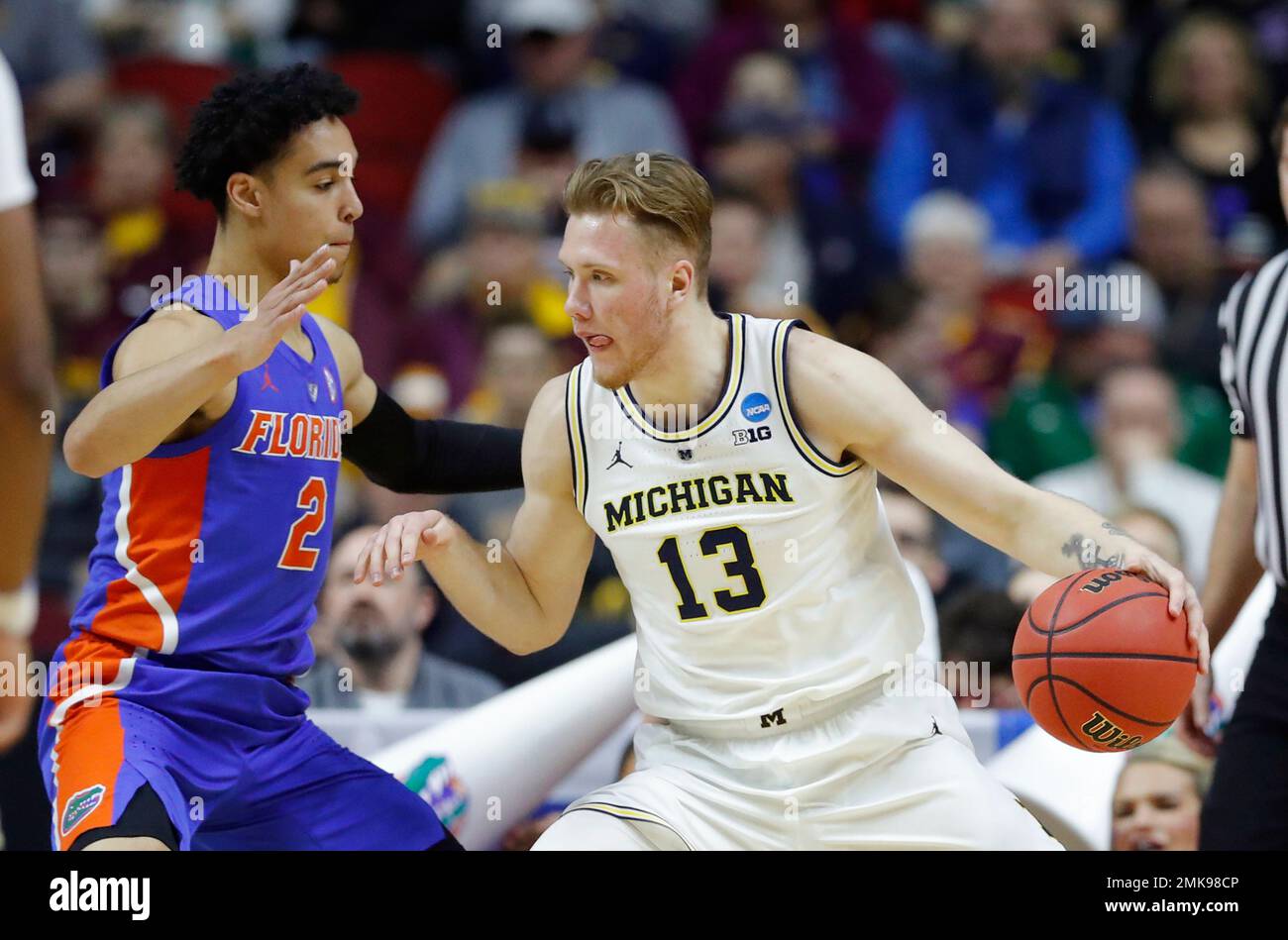 Michigan forward Ignas Brazdeikis (13) drives around Florida guard Andrew Nembhard during a ...