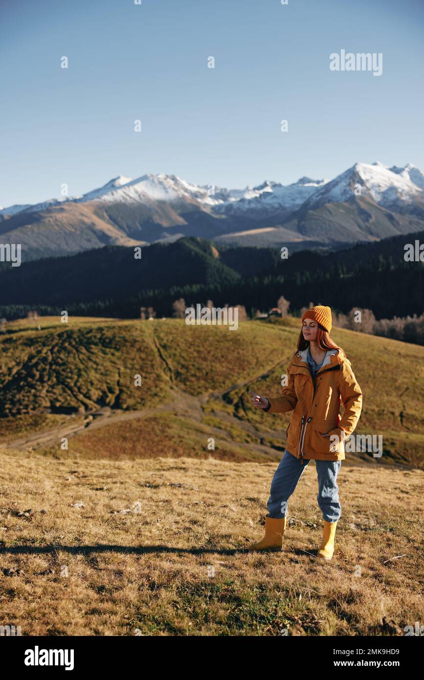 Autumn woman walking up the hill in full smile travels to the mountains ...