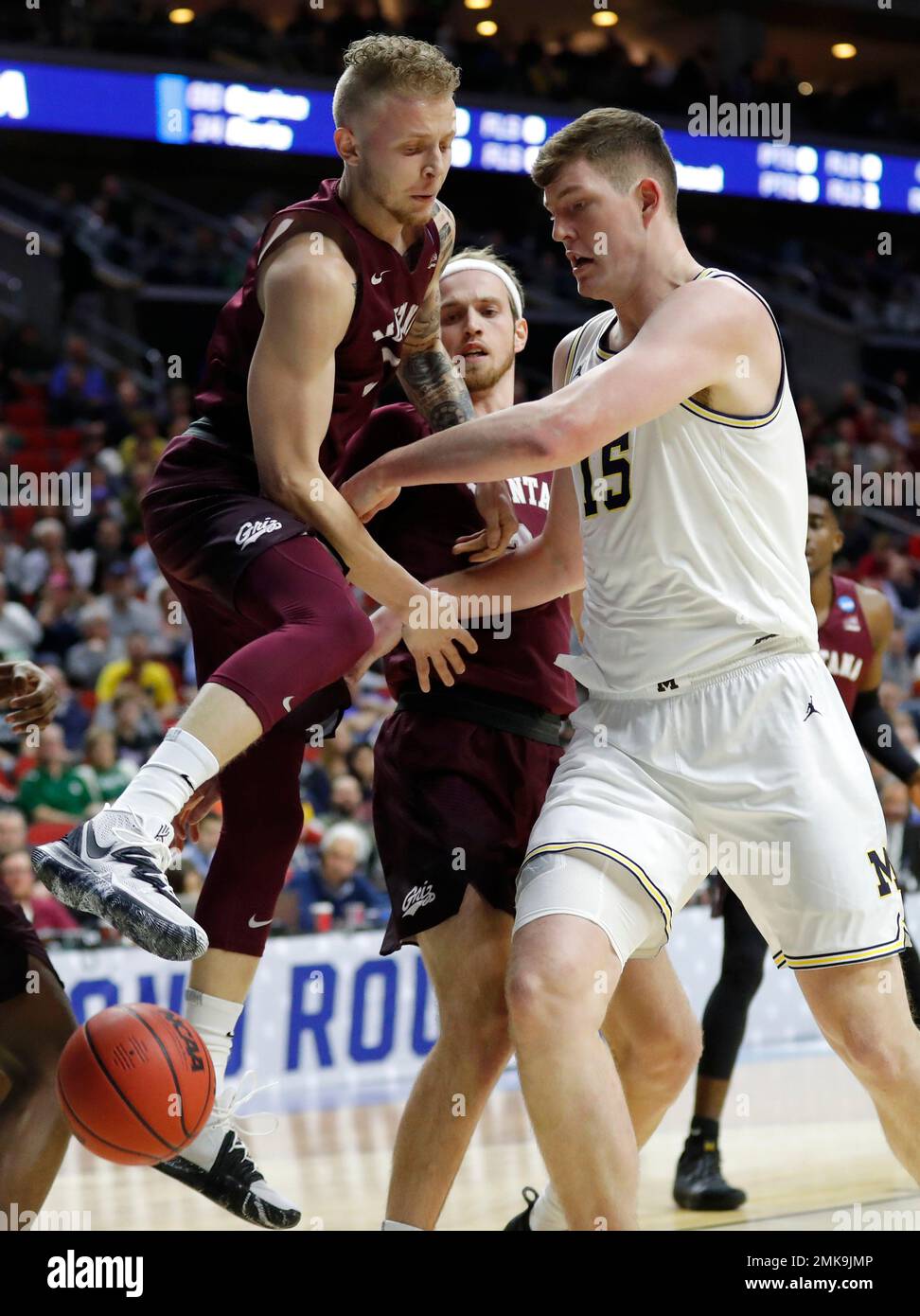 Montana guard Timmy Falls, left, fights for a loose ball with Michigan ...
