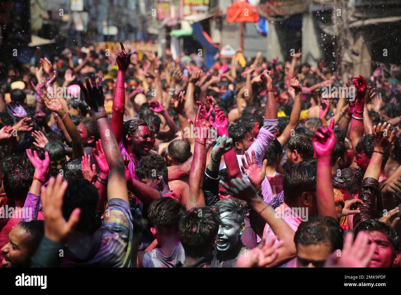 Indian revelers, faces smeared with colored powder, dance during ...