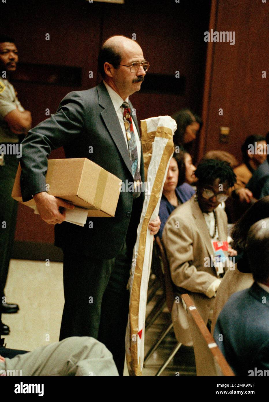 Los Angeles Police Det. Tom Lange carries evidence at the O.J. Simpson double murder trial in ...