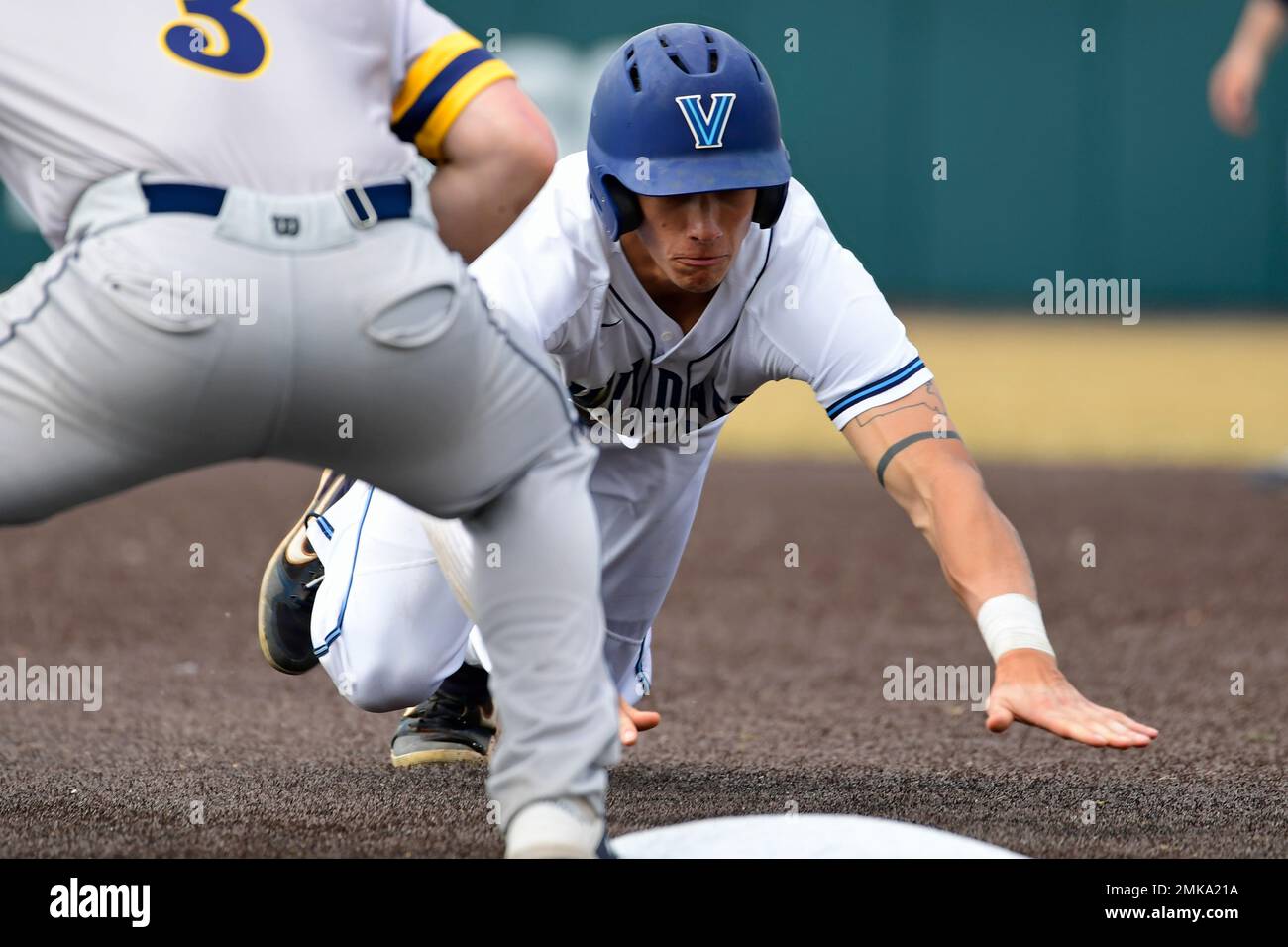 Villanova's Dylan McNary slides back safely into first base against La ...