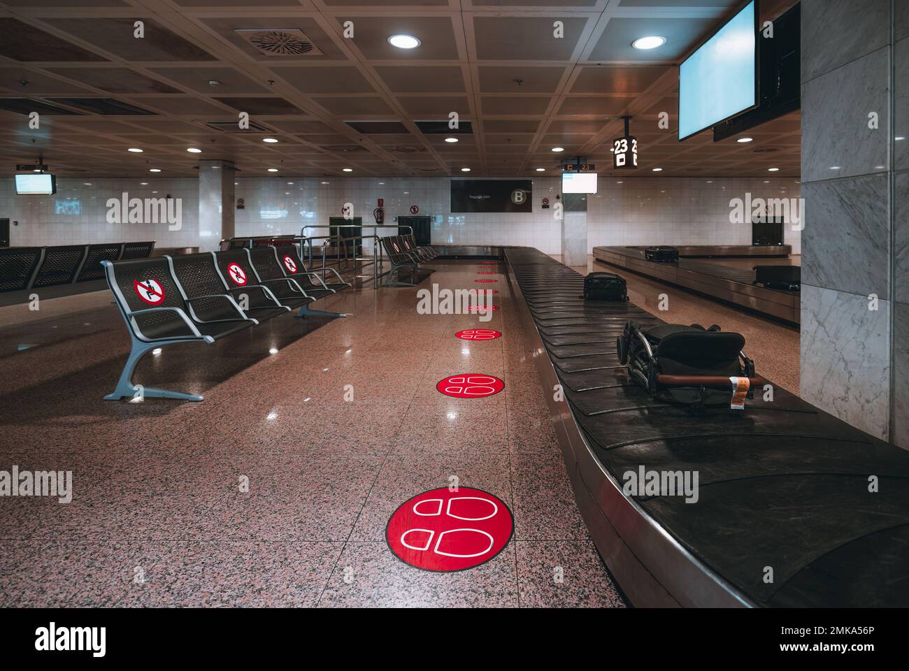 An empty baggage claim zone of a modern airport terminal with rows of ...